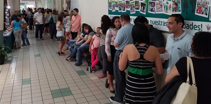 Largas filas en centros comerciales para inscribirse - Primera Hora